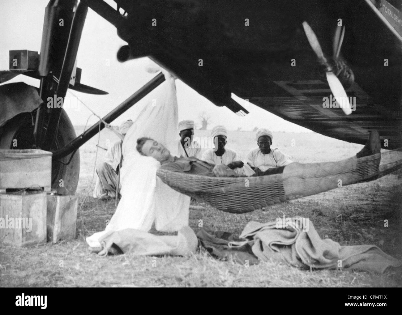 Pilot falls asleep under his plane in Africa, 1929 Stock Photo - Alamy