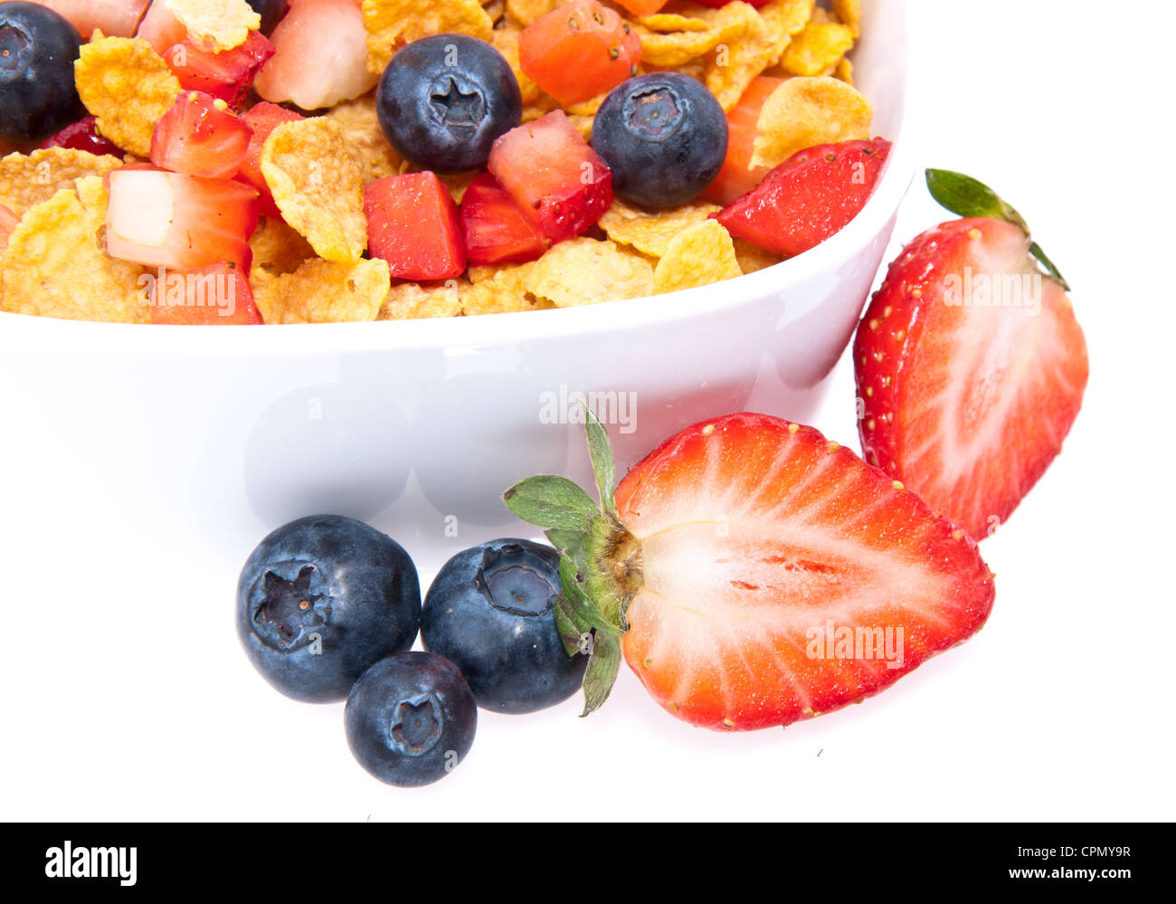 Cornflakes with fresh fruits in a bowl isolated on white background ...