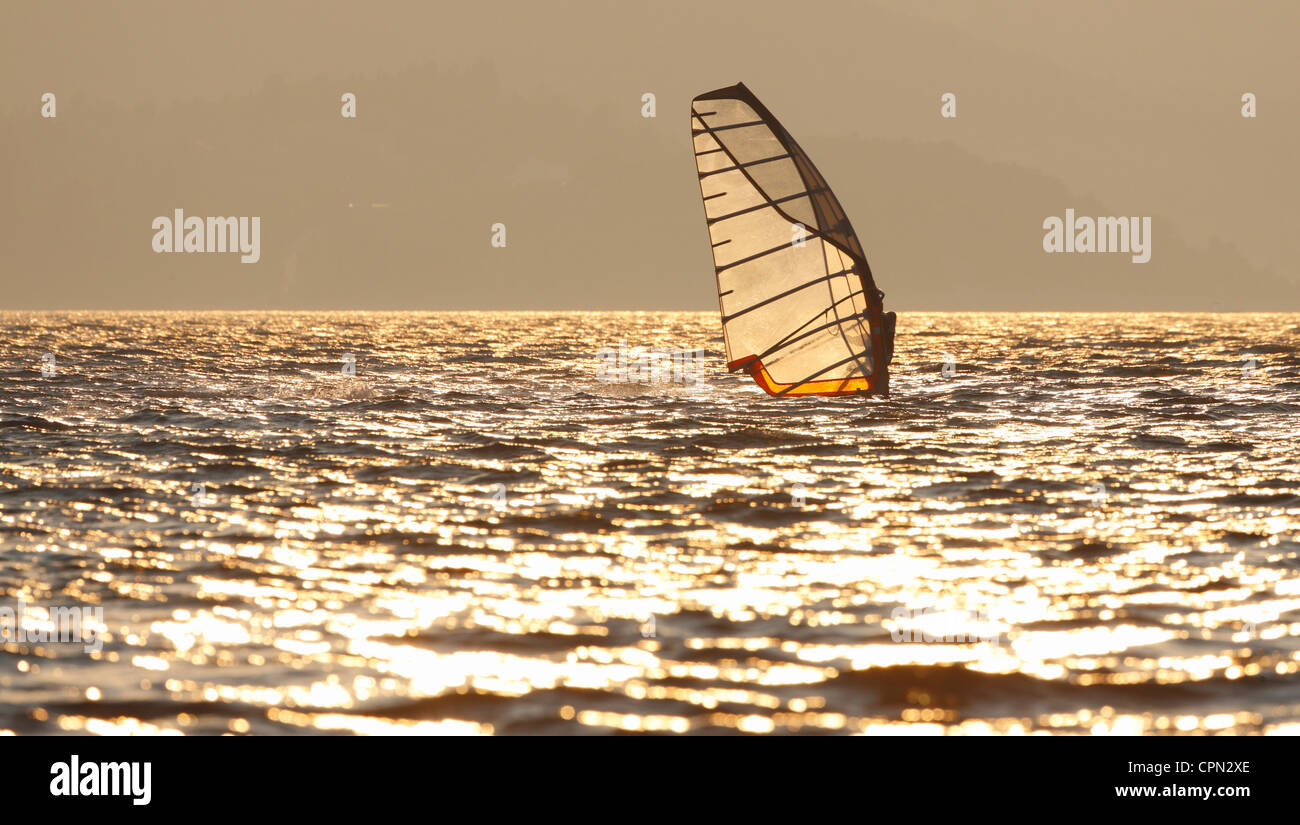 Windsurfing at sunset Stock Photo - Alamy