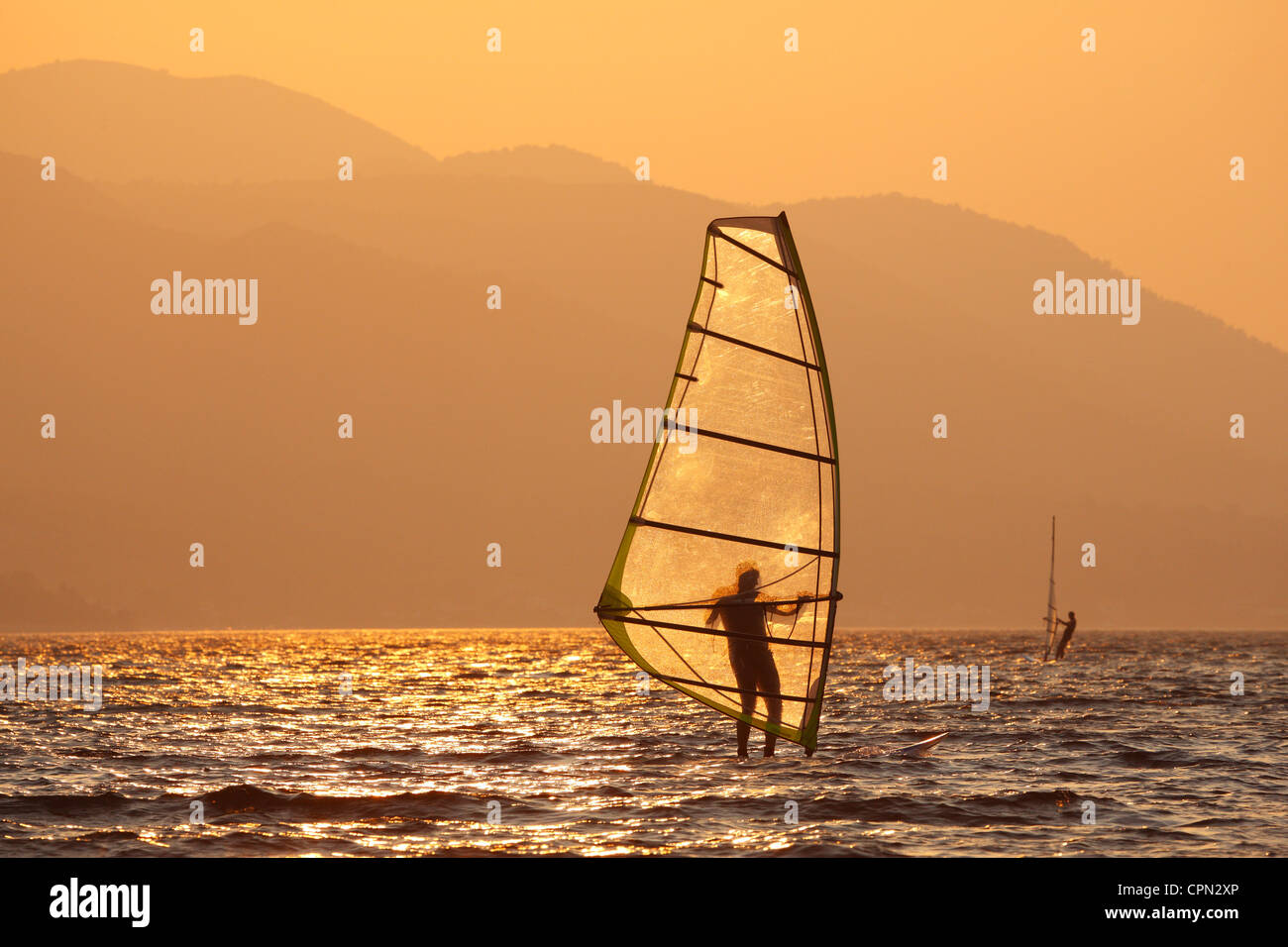 Windsurfing at sunset Stock Photo - Alamy