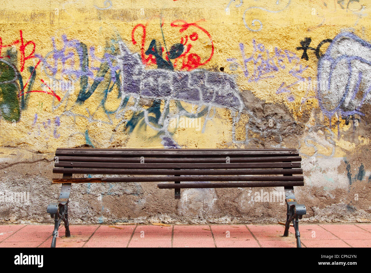 Damaged wooden bench against graffiti Stock Photo - Alamy