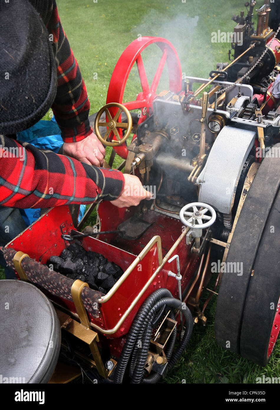 Man stoking boiler of model traction engine Stock Photo - Alamy