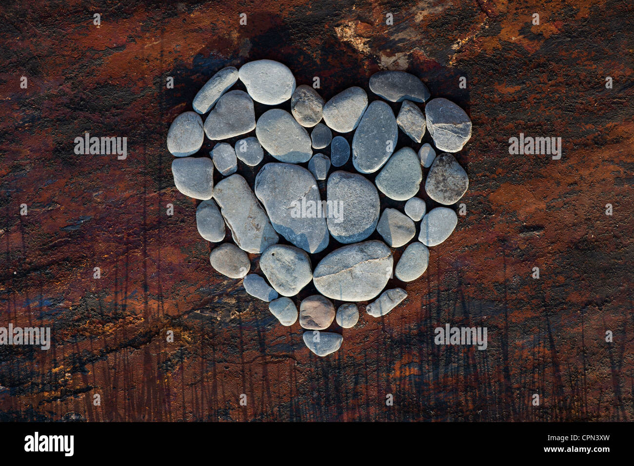 Heart shape pebbles on a texture slate background Stock Photo - Alamy