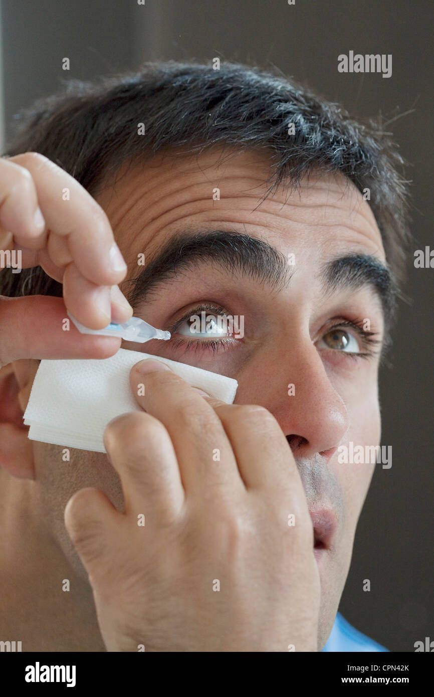 MAN USING EYE LOTION Stock Photo - Alamy