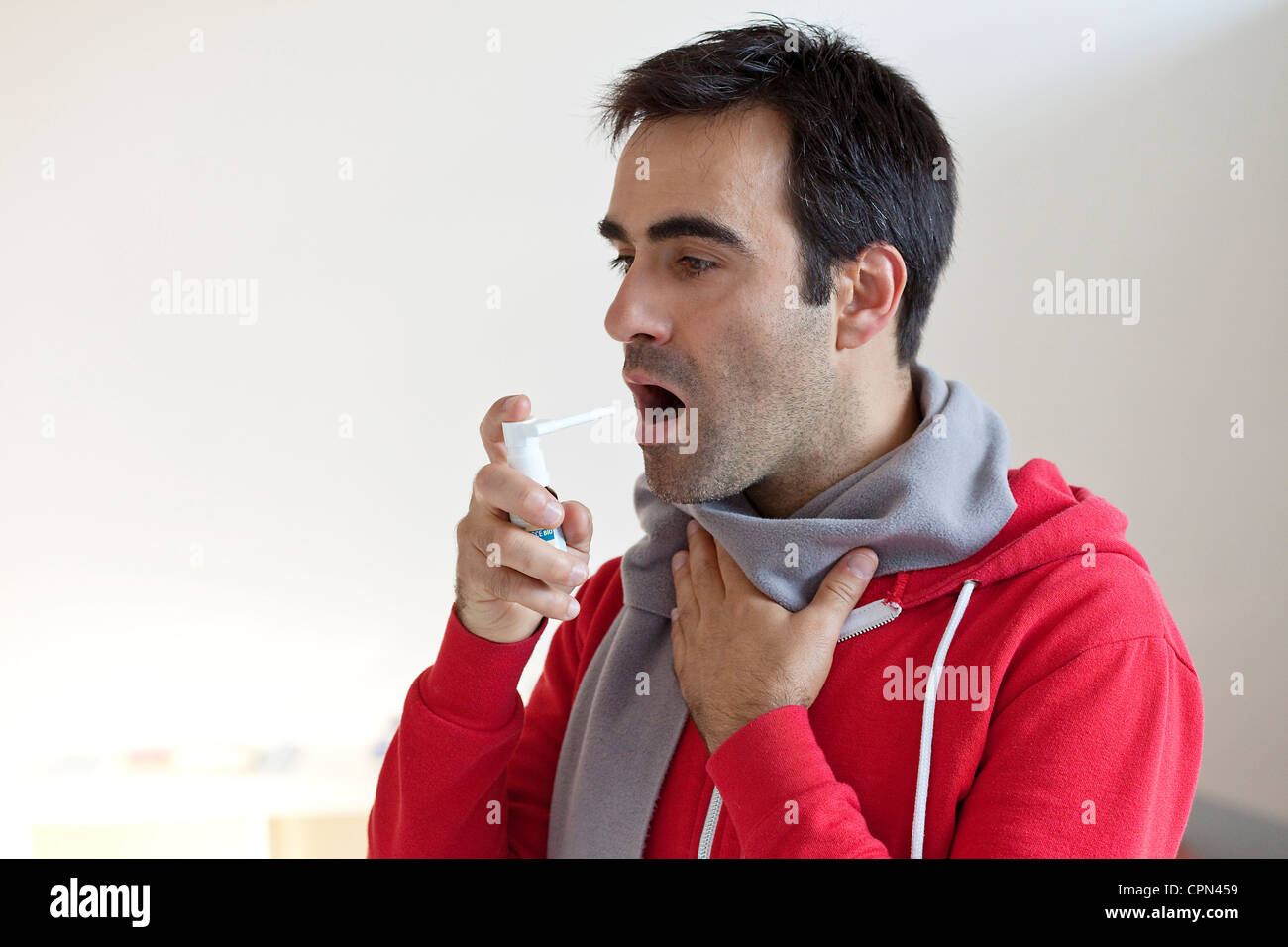 MAN USING MOUTH SPRAY Stock Photo - Alamy