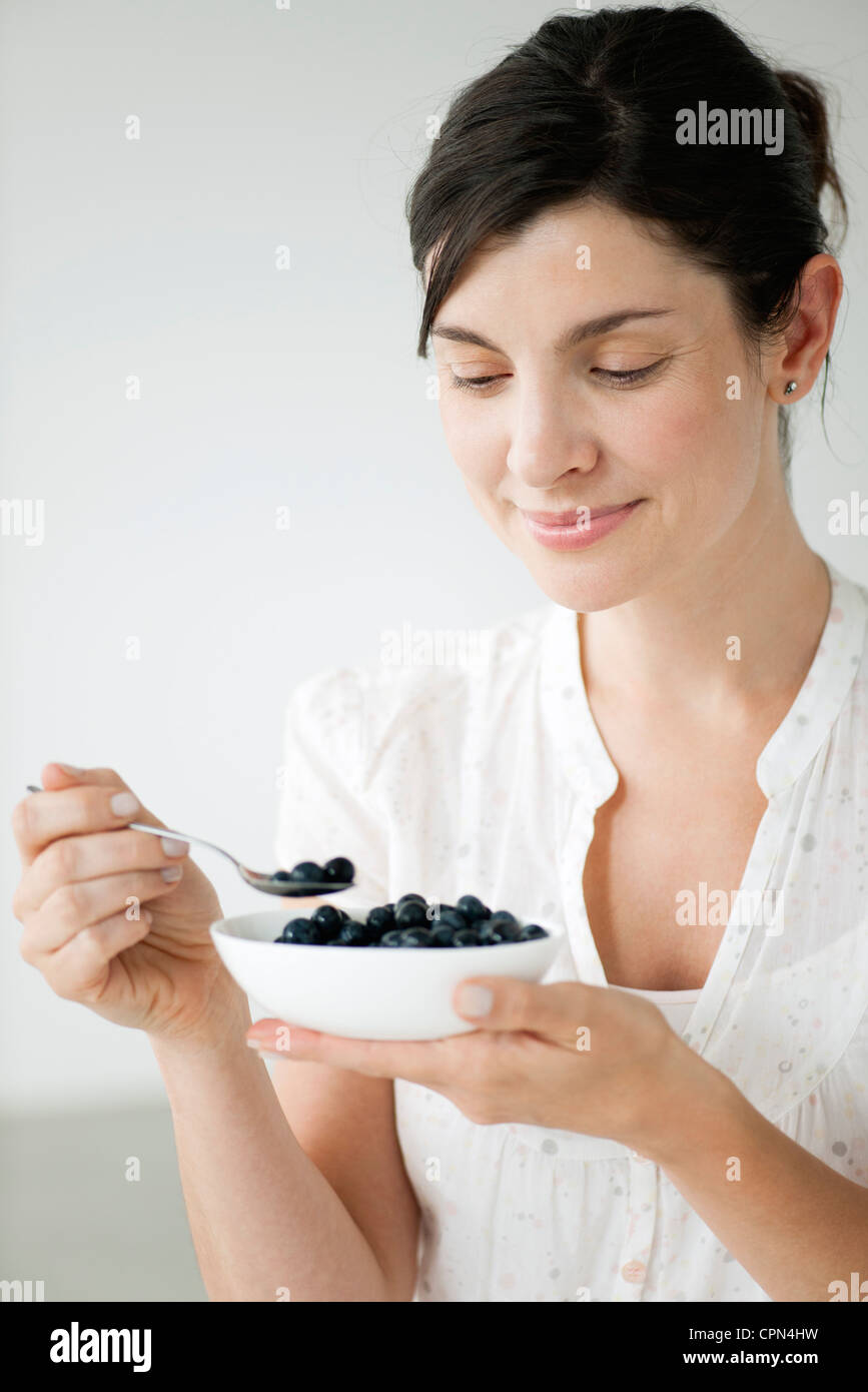 Woman eating bowl of fresh blueberries Stock Photo - Alamy