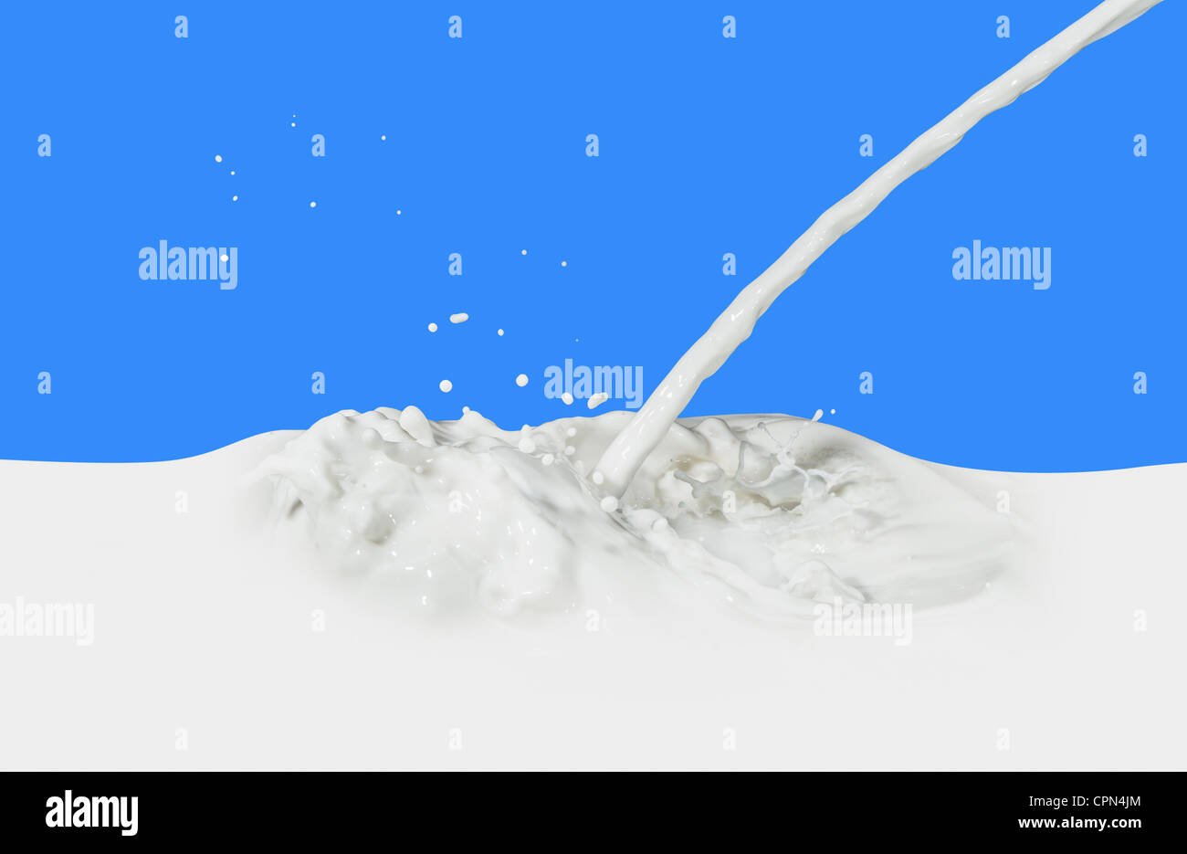 splashing milk isolated on blue background Stock Photo - Alamy
