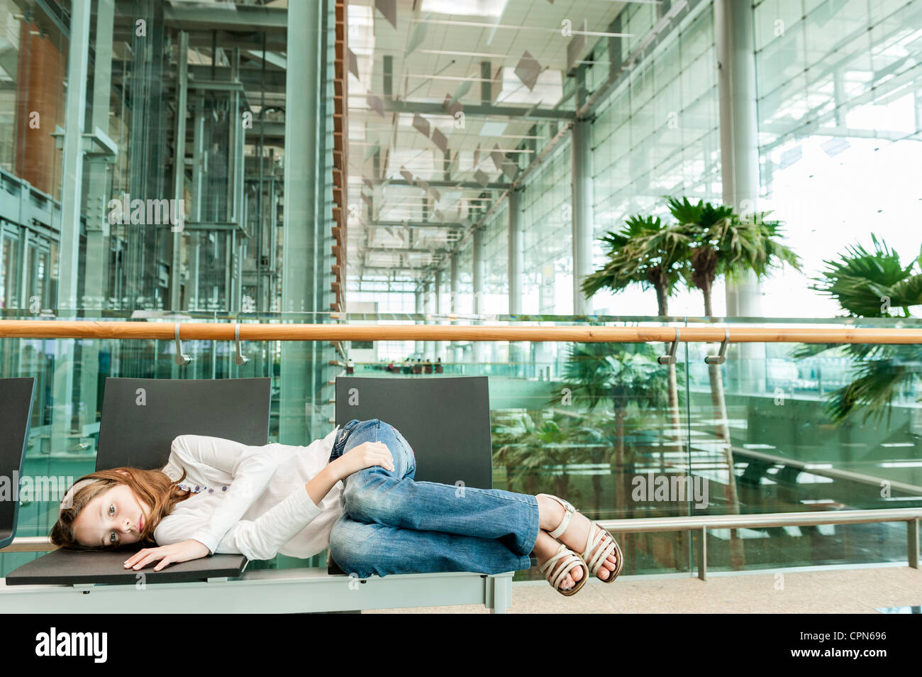 Girl lying on chairs in airport Stock Photo - Alamy