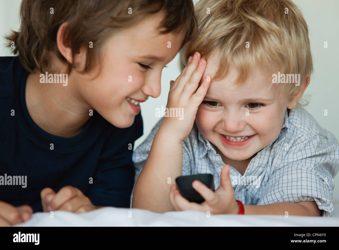 Brothers playing with cell phone Stock Photo - Alamy