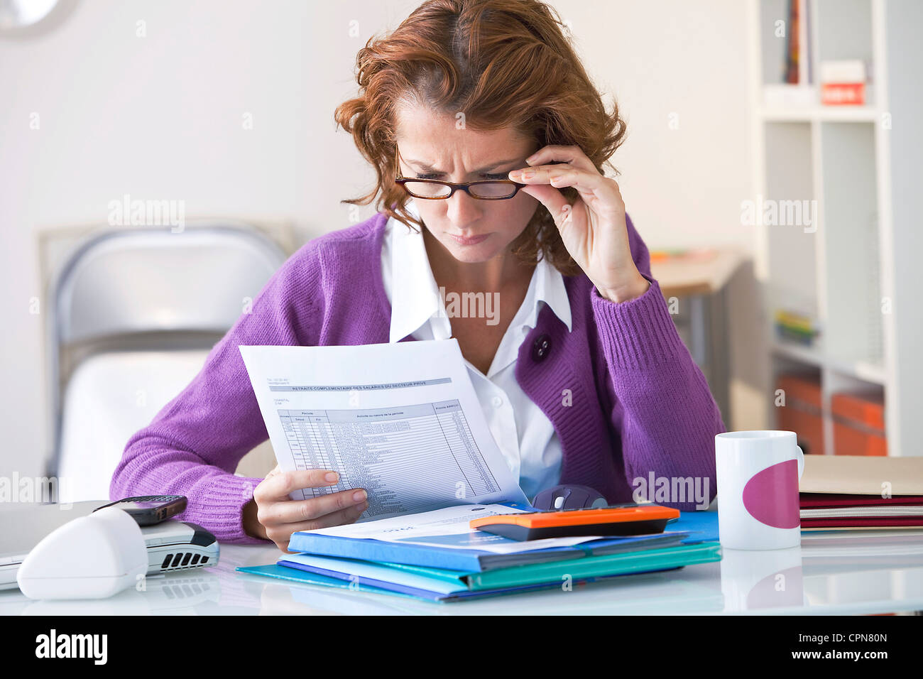 Old woman seated reading papers hi-res stock photography and images - Alamy