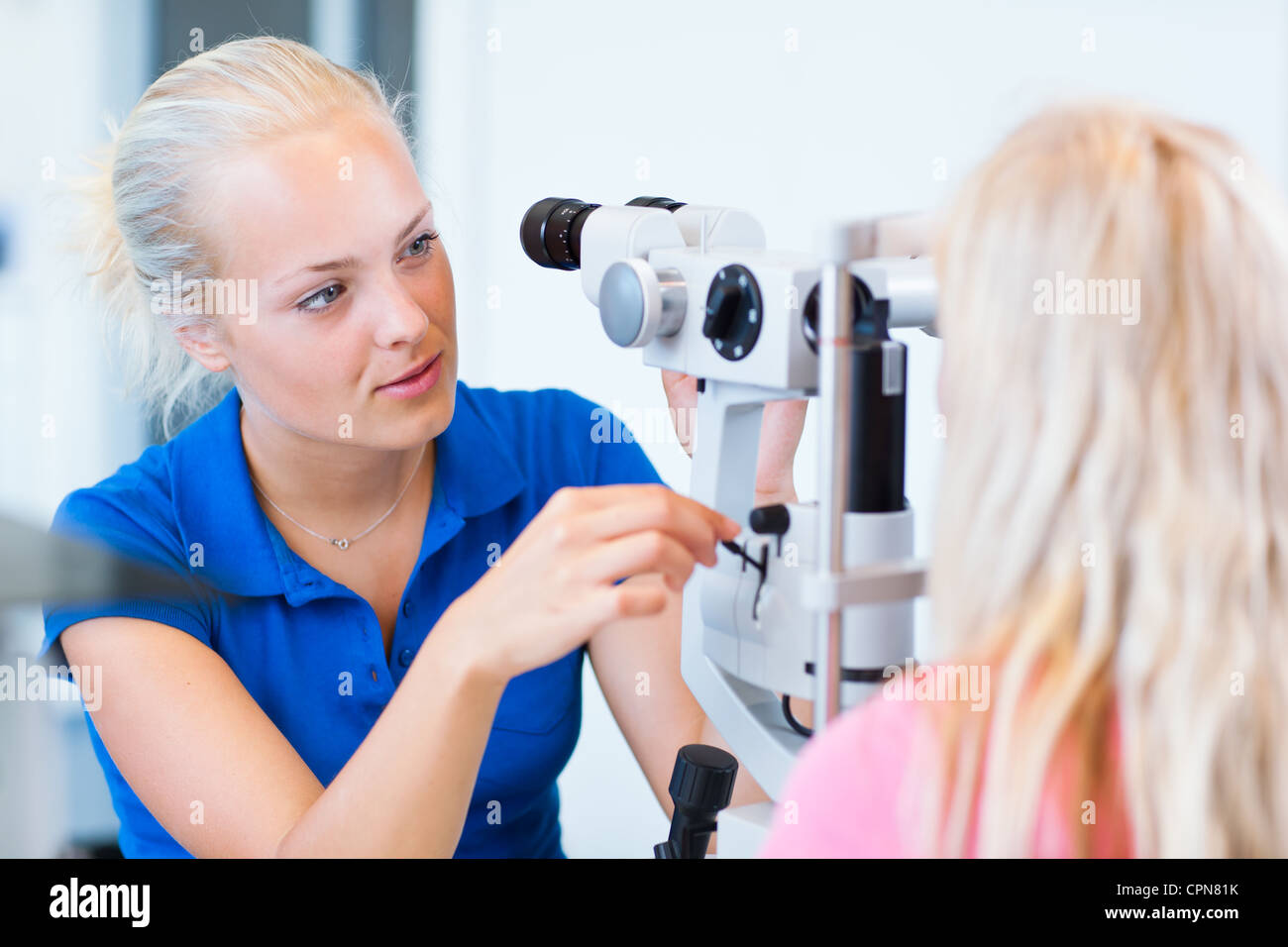 optometry concept - portrait of a young pretty optometrist using slit ...