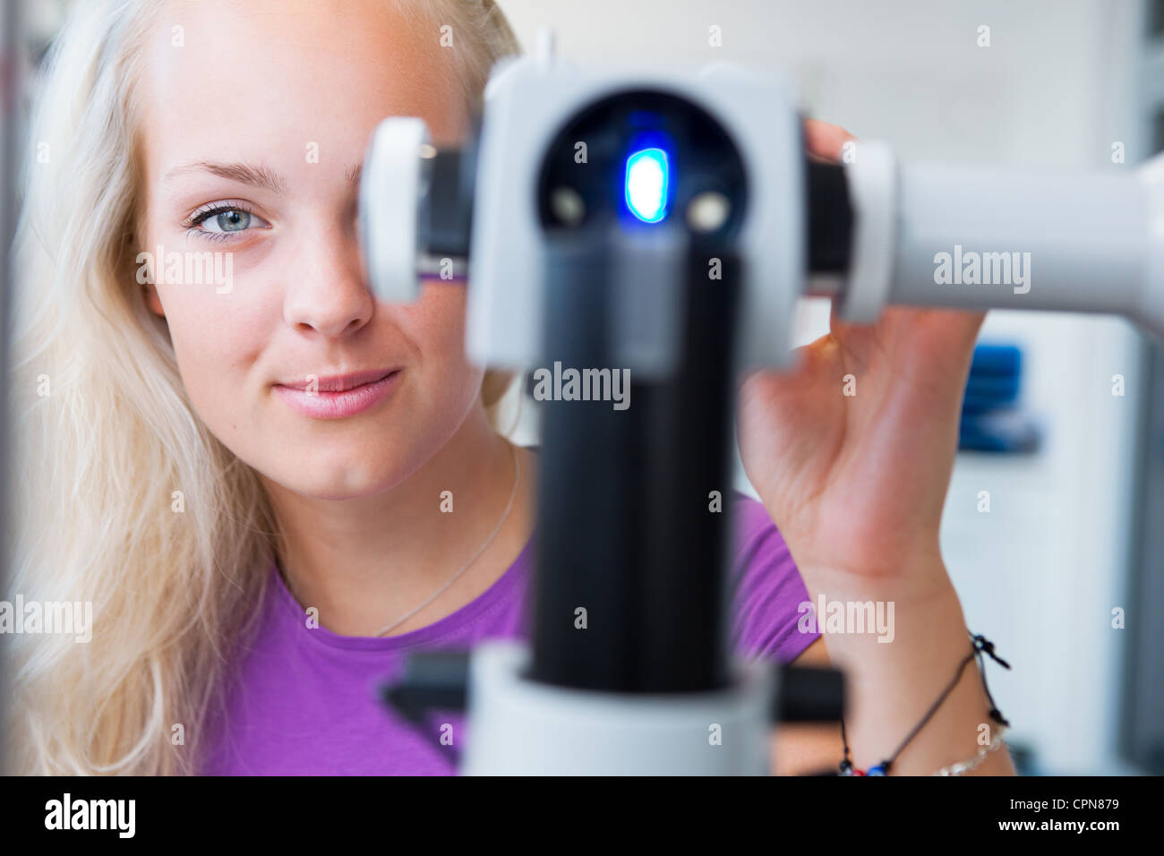 optometry concept - portrait of a young pretty optometrist using slit ...