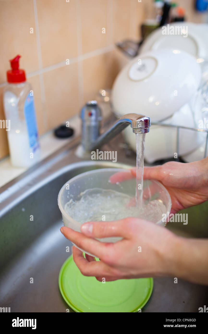 Washing of the dishes - woman hands rinsing dishes under running water ...