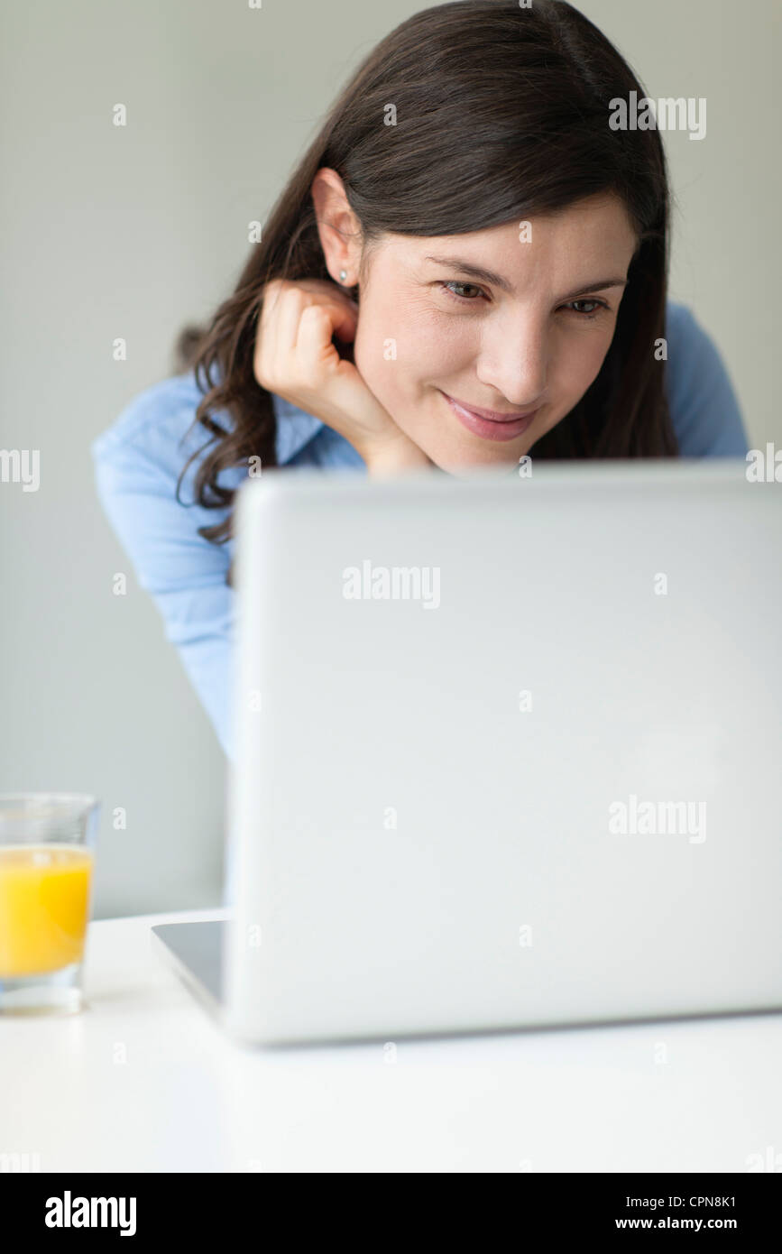 Mid-adult woman using laptop computer Stock Photo - Alamy
