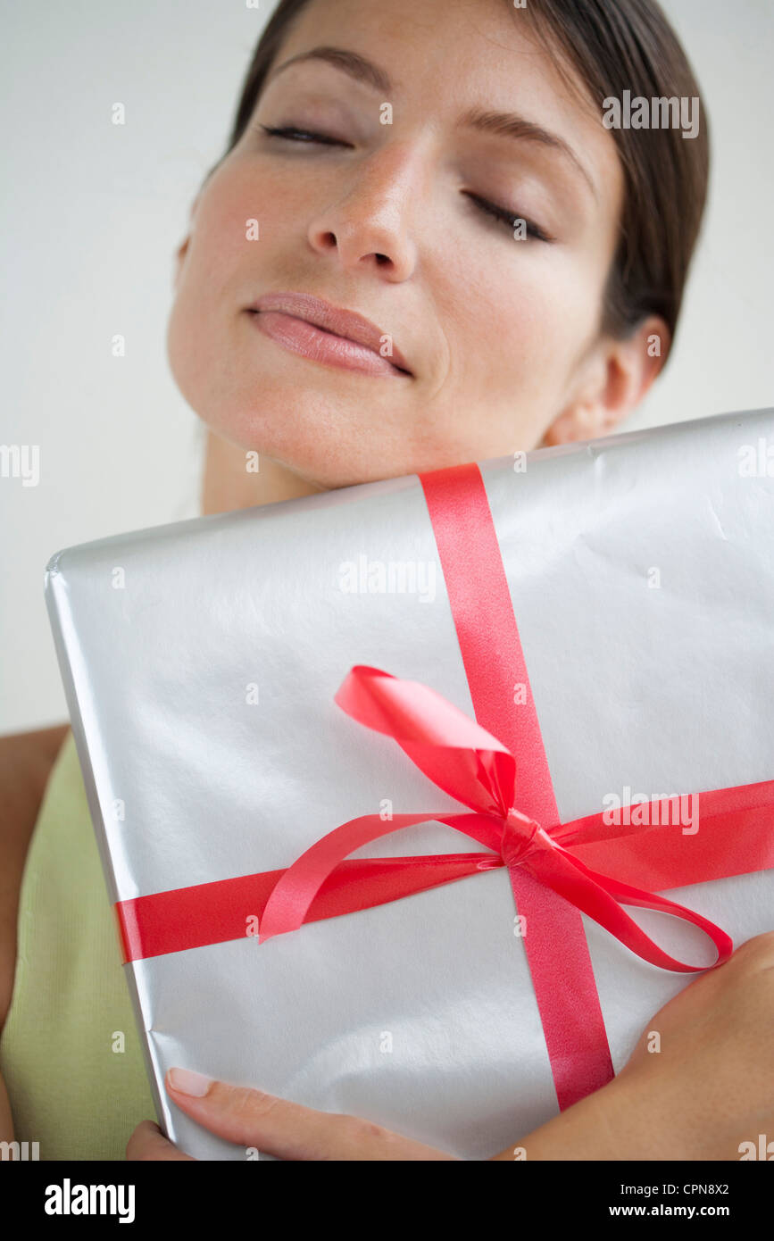 Woman embracing gift, eyes closed Stock Photo - Alamy