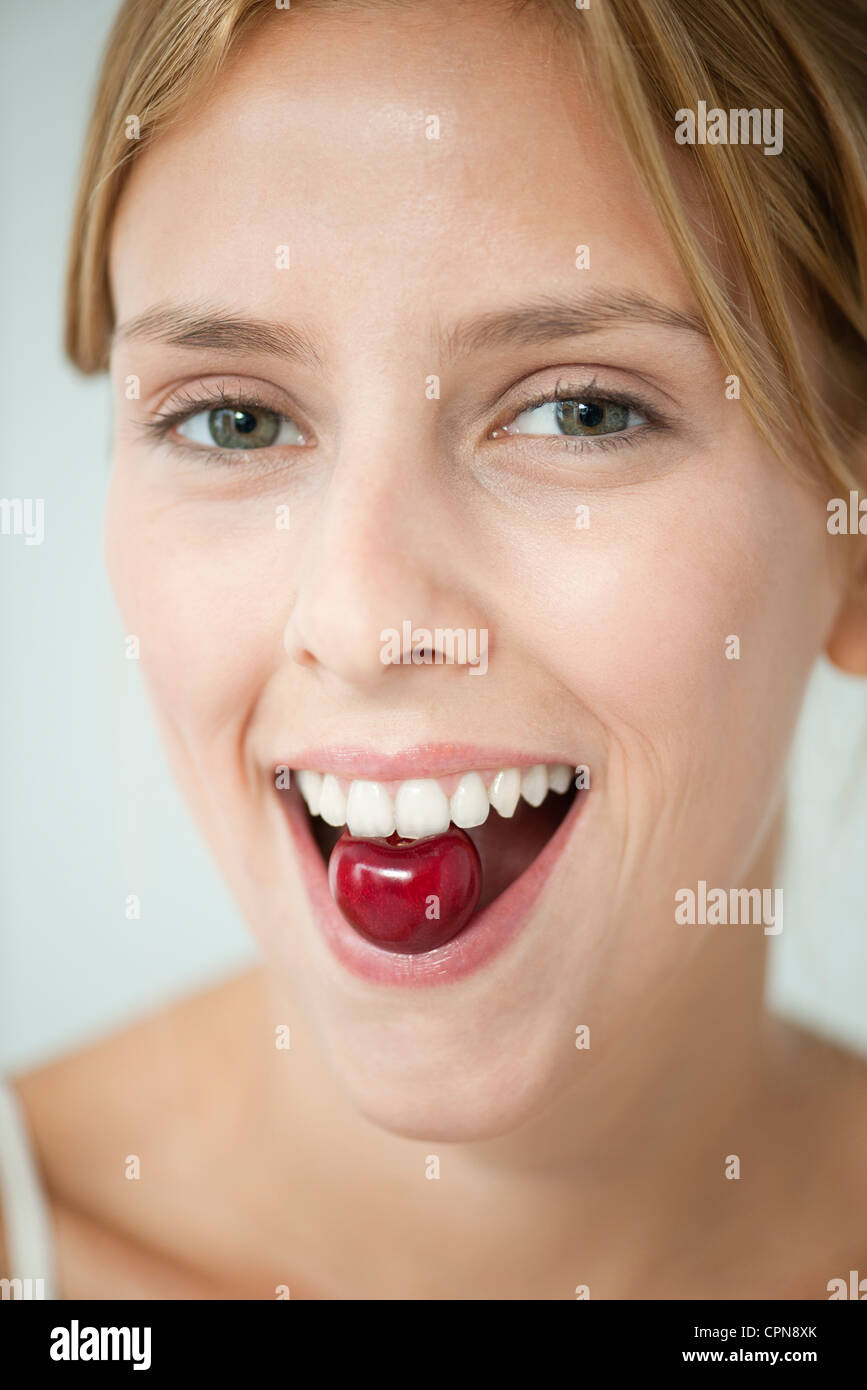 Young woman eating cherry Stock Photo - Alamy