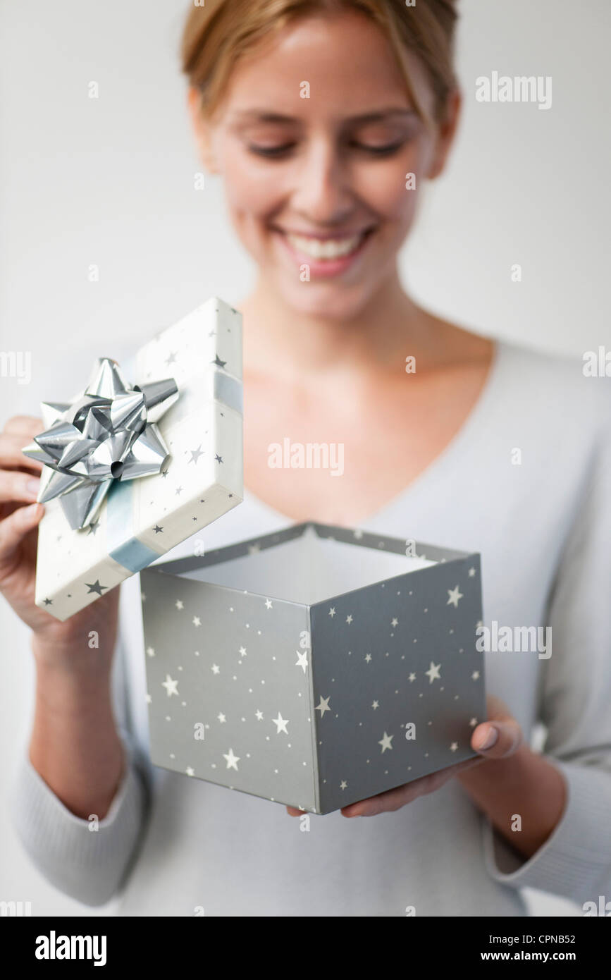 Young woman opening gift box Stock Photo - Alamy