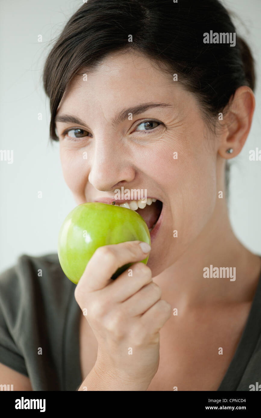Mid-adult woman biting into apple Stock Photo - Alamy