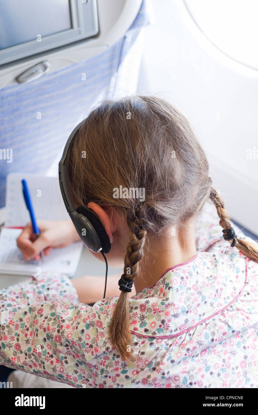 Girl writing on airplane Stock Photo - Alamy