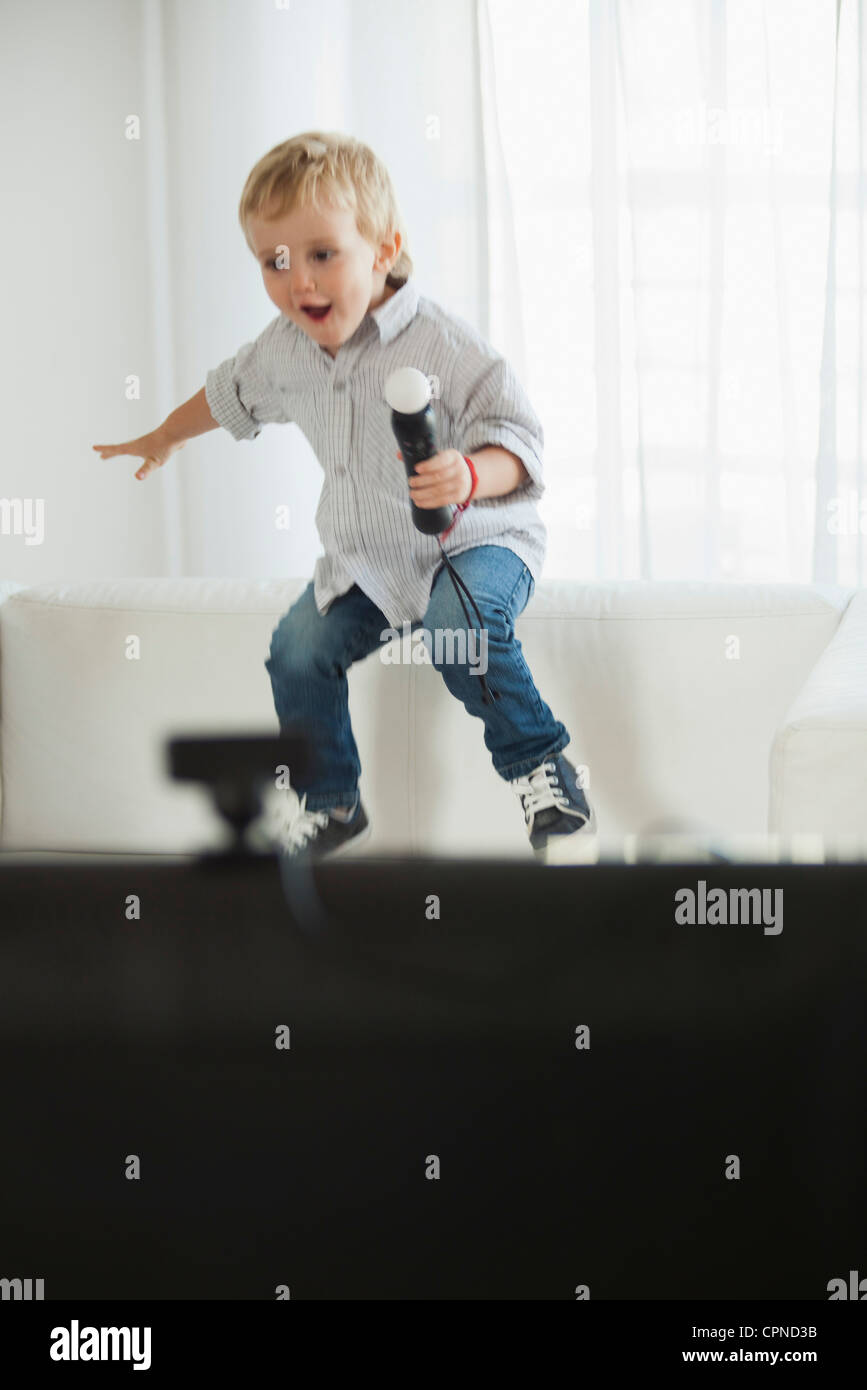 Child is jumping on the sofa in the living room hi-res stock ...