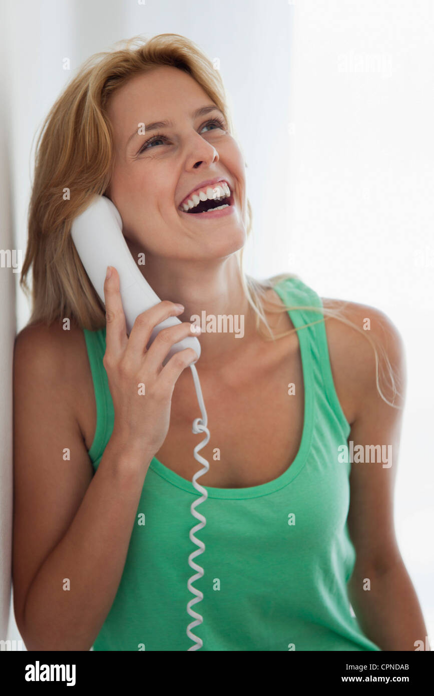 Young woman talking on landline phone, laughing Stock Photo - Alamy