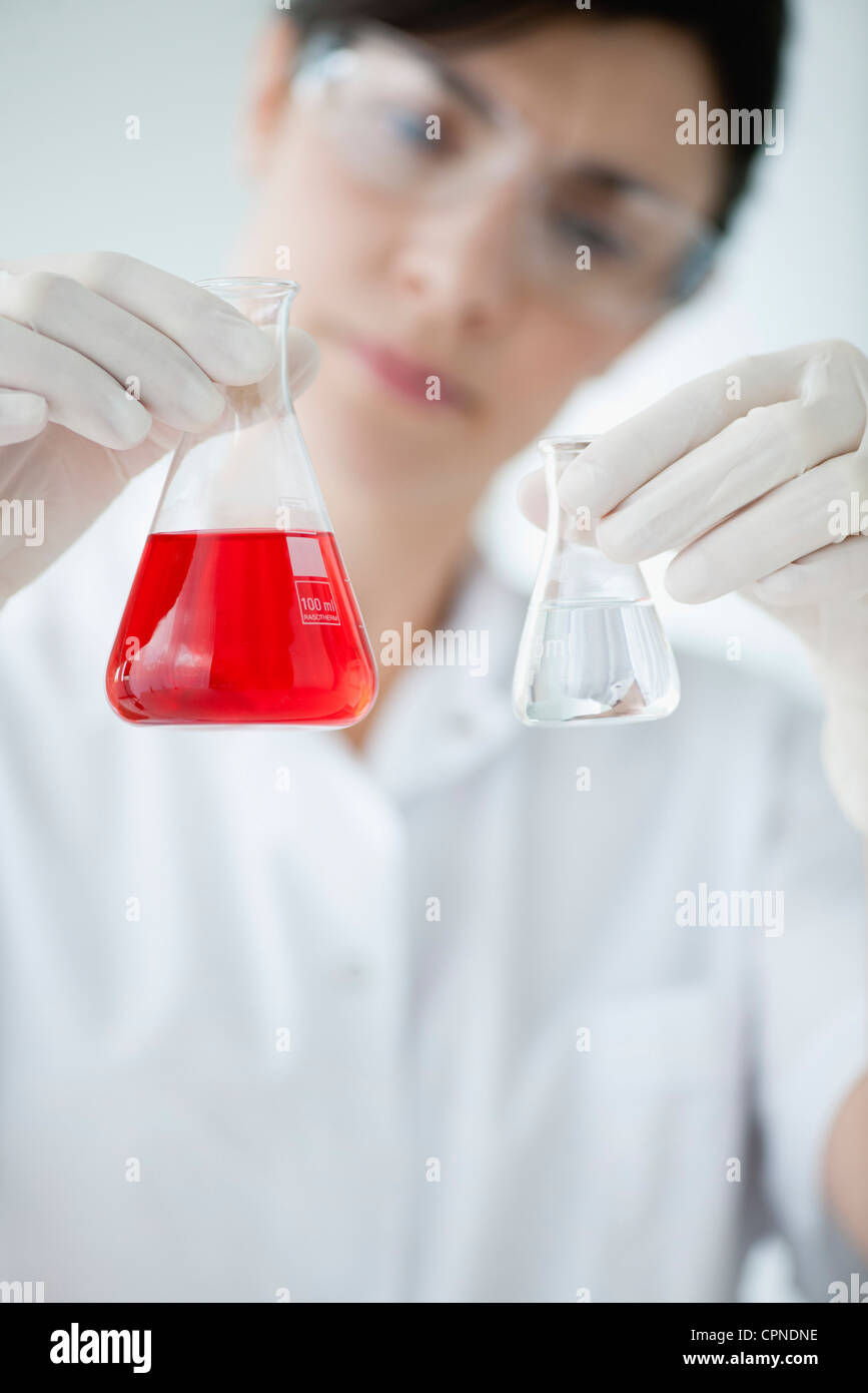 Scientist holding conical flasks containing liquid Stock Photo - Alamy