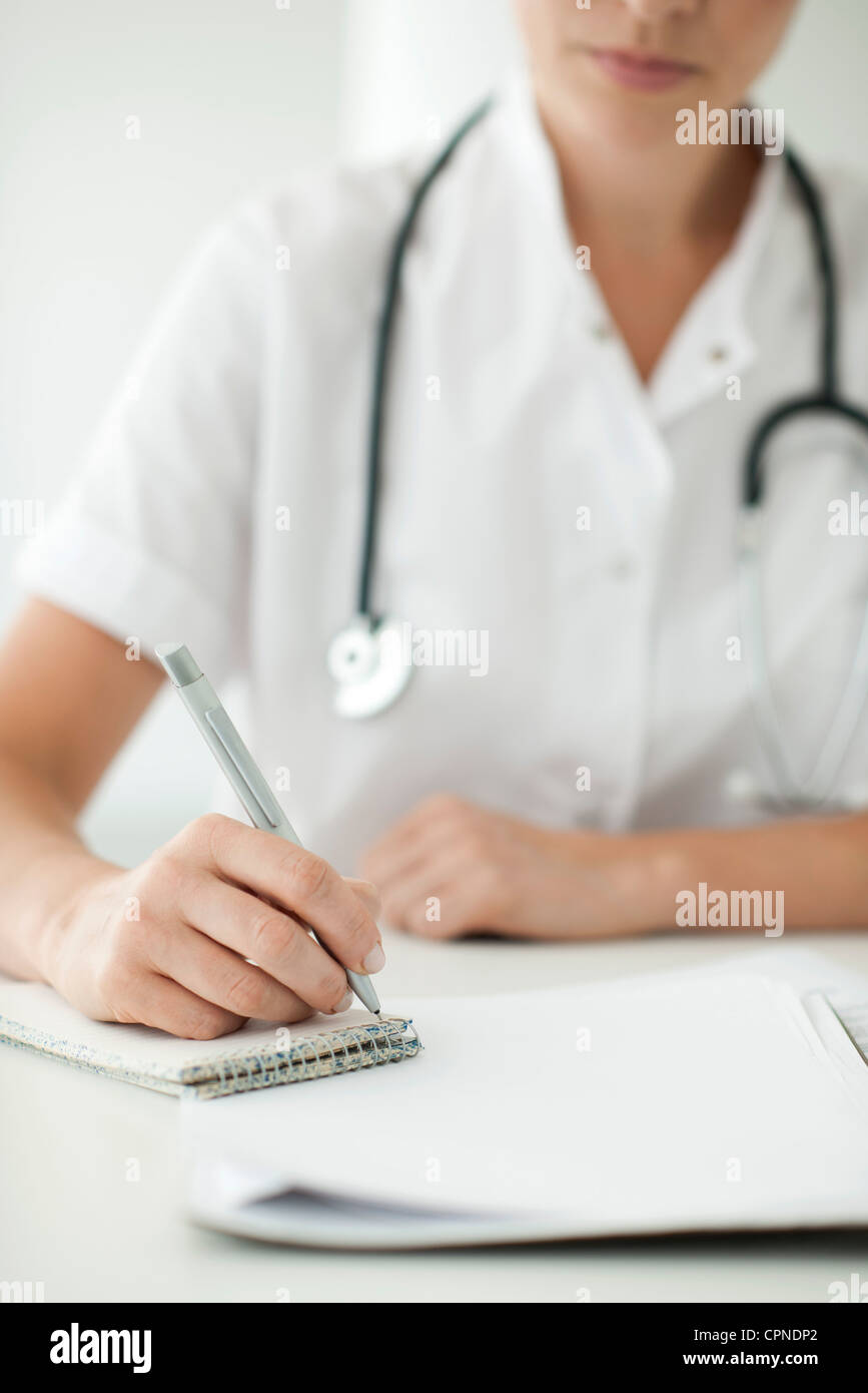 Doctor writing notes on notepad, cropped Stock Photo - Alamy