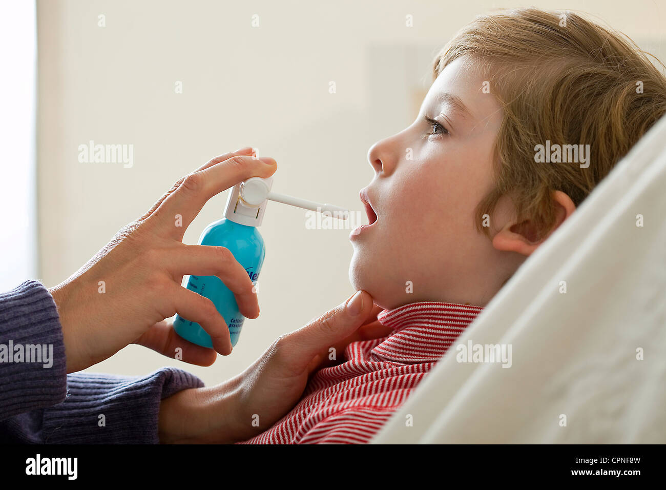 CHILD USING SPRAY IN MOUTH Stock Photo - Alamy