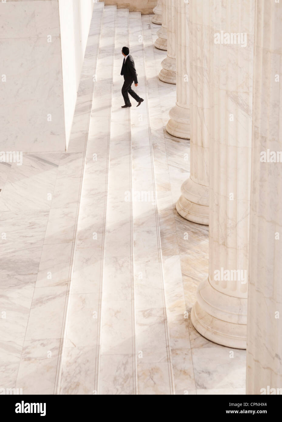 person climbing steps next to columns Stock Photo - Alamy