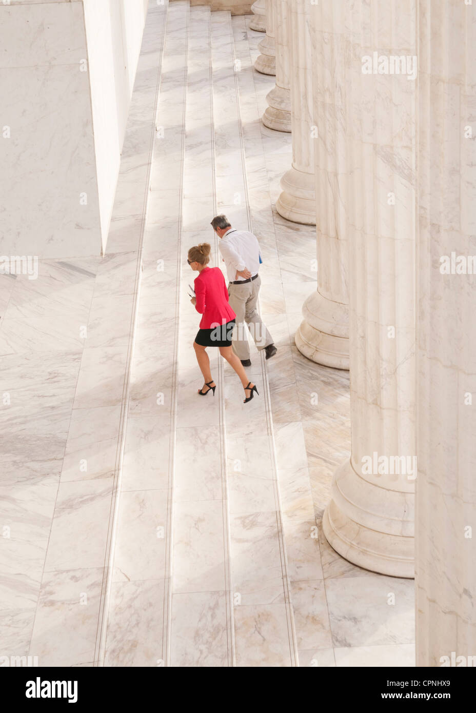 person climbing steps next to columns Stock Photo - Alamy