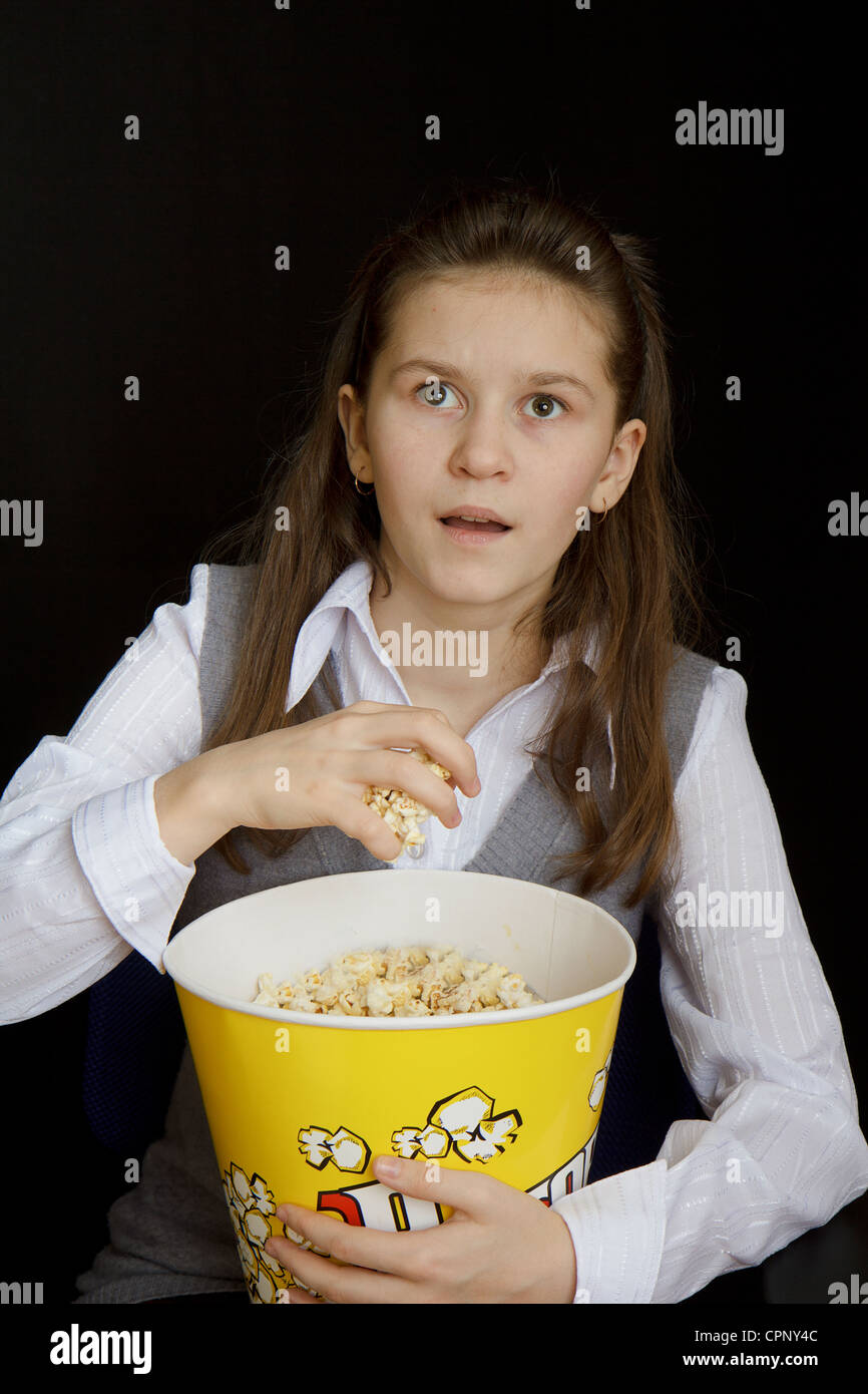 emotional girl with popcorn on a black background Stock Photo - Alamy