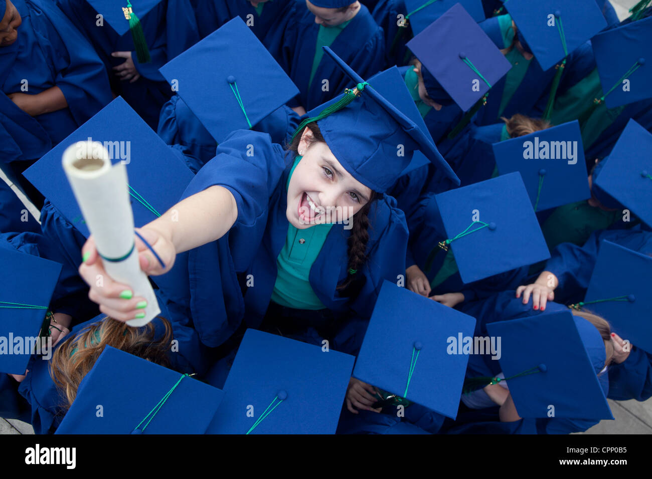 A child celebrates and exam pass in a fake degree honors ceremony at a ...