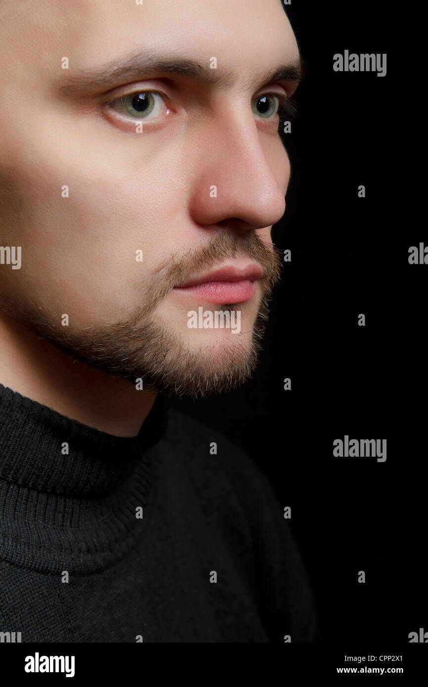 face of the young unshaven man in a black background Stock Photo - Alamy