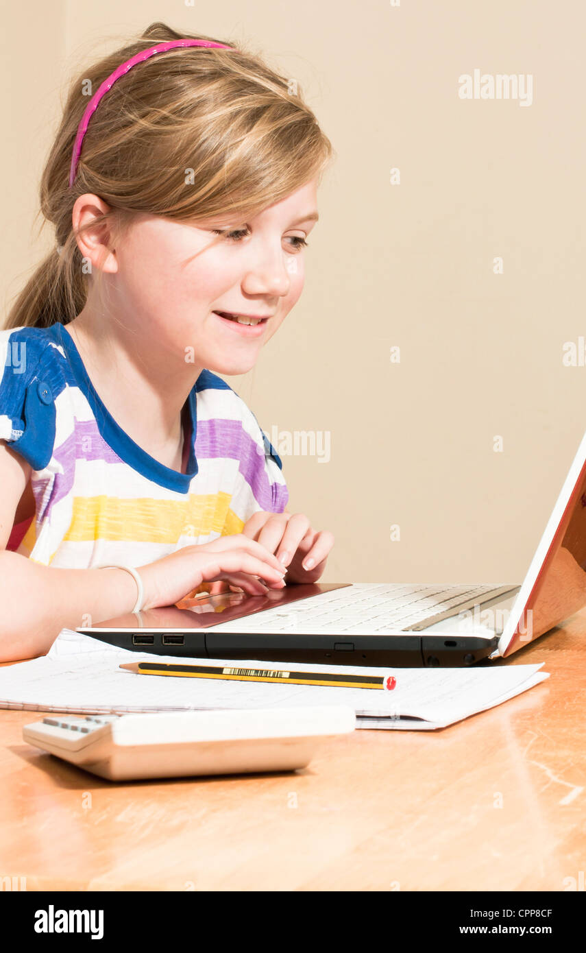 Girl doing homework with laptop Stock Photo - Alamy