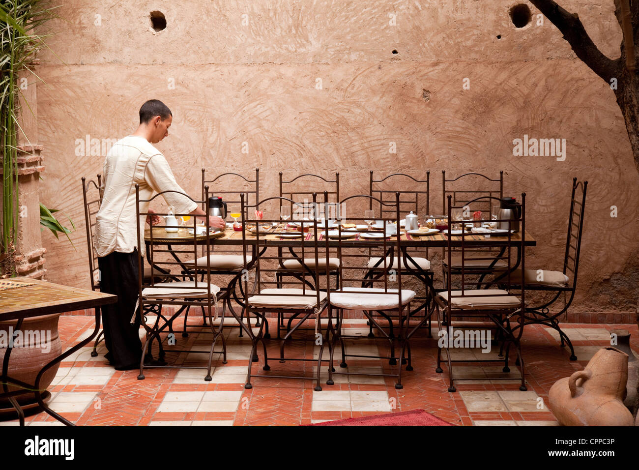 A waiter laying the table for breakfast, Riad Aladdin, Marrakech ...