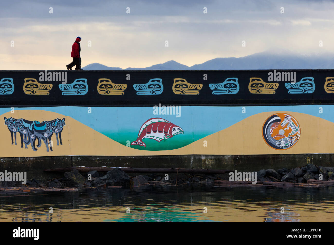 Two people walking along the breakwater in Victoria, BC, Canada ...