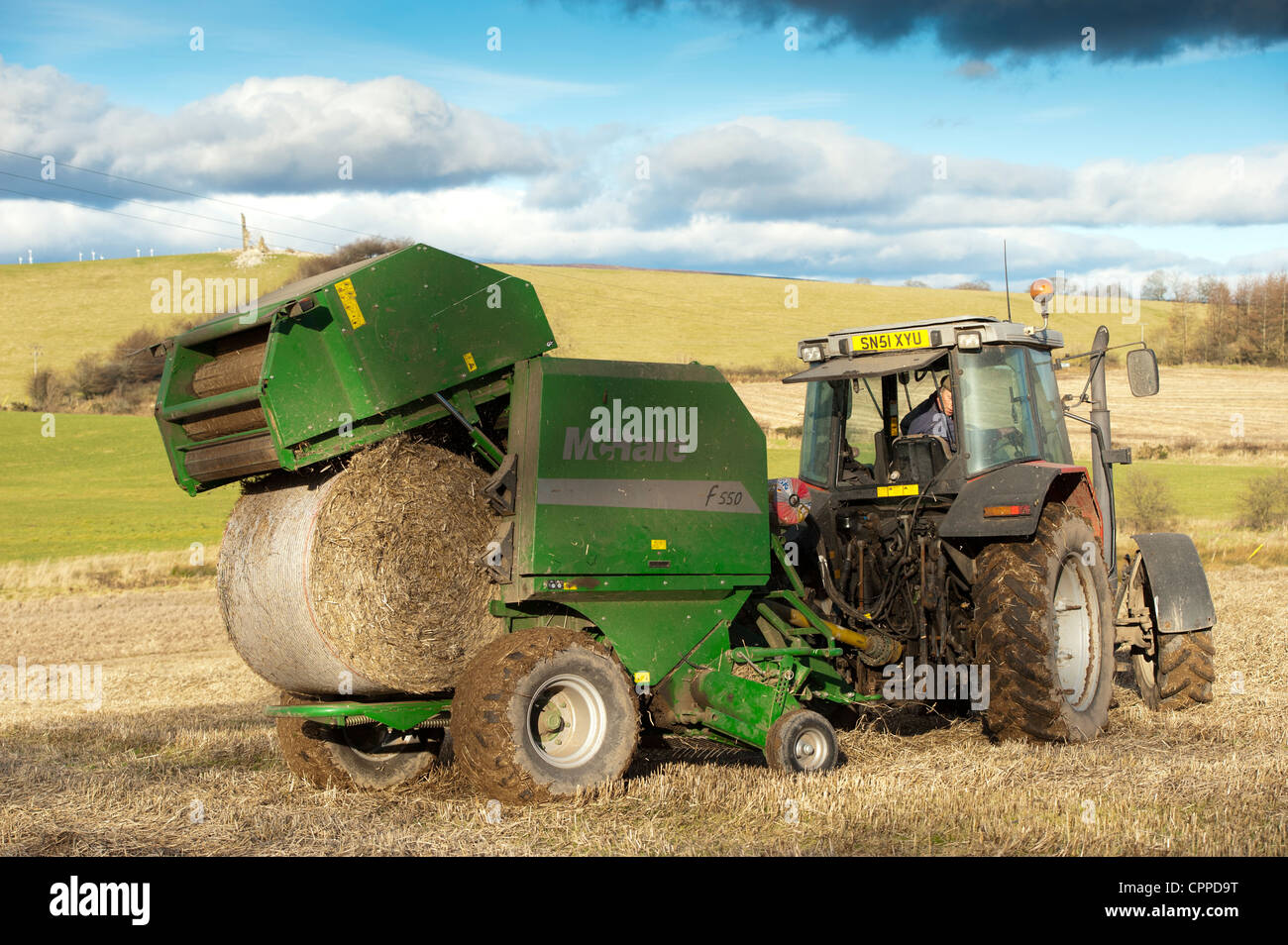 Baling straw with McHale round baler and Massey Ferguson tractor Stock ...