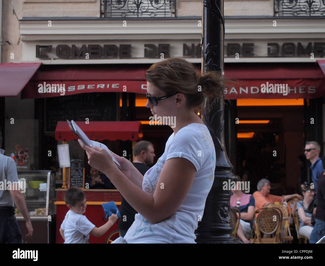 Woman tourist reading guide book near Notre Dame in Paris, France, May ...
