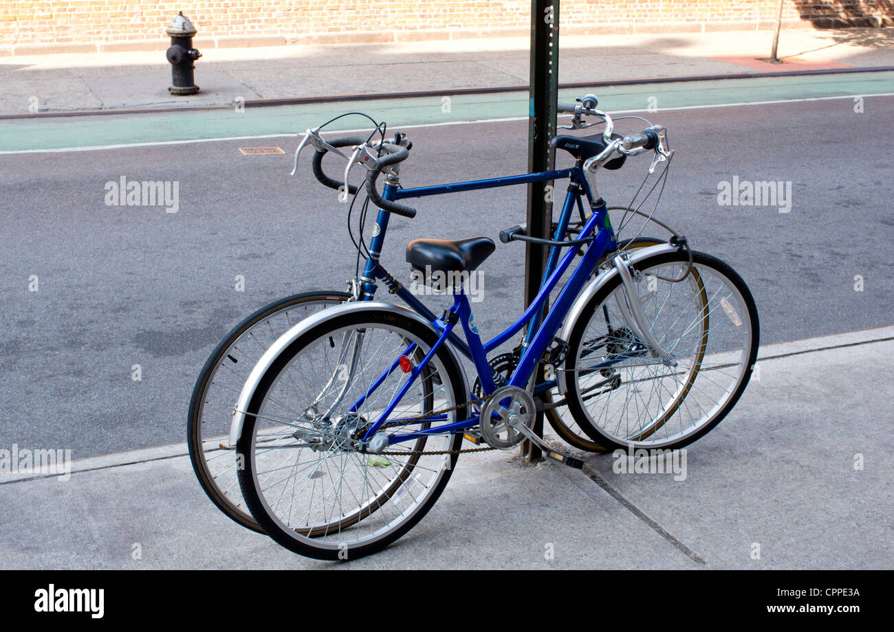 Two bicycles, one a man's and one a woman's, chained together on a ...