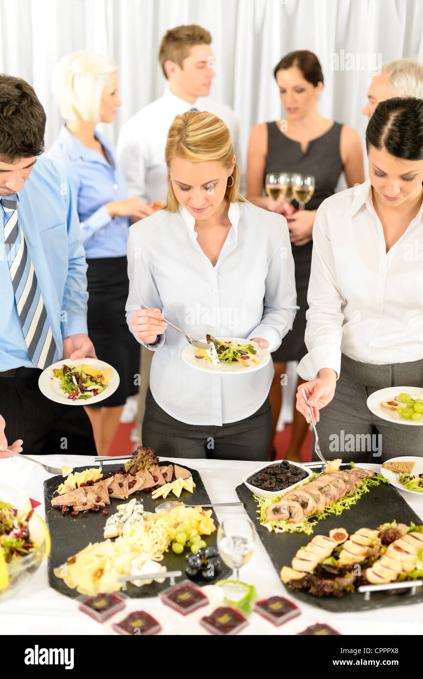 Company meeting catering smiling business people eat buffet appetizers ...