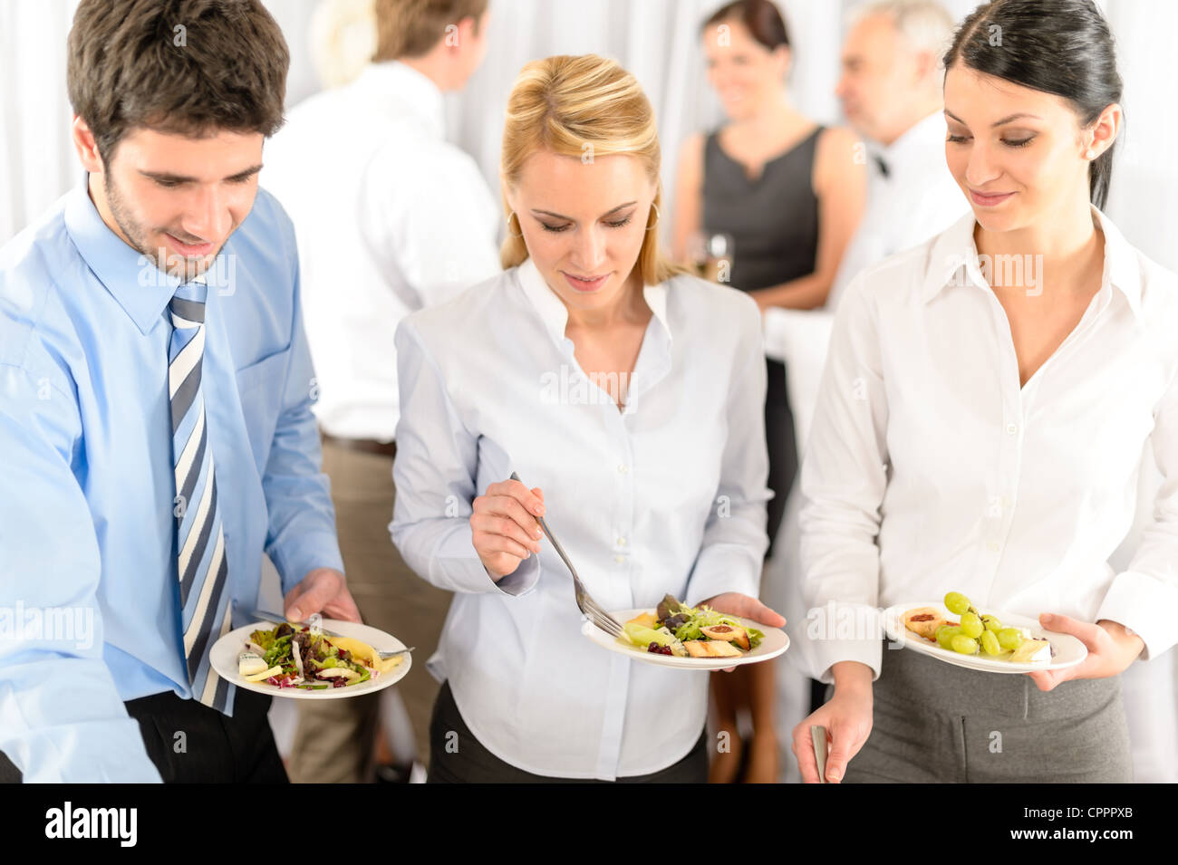 Business colleagues serve themselves at buffet catering service company ...