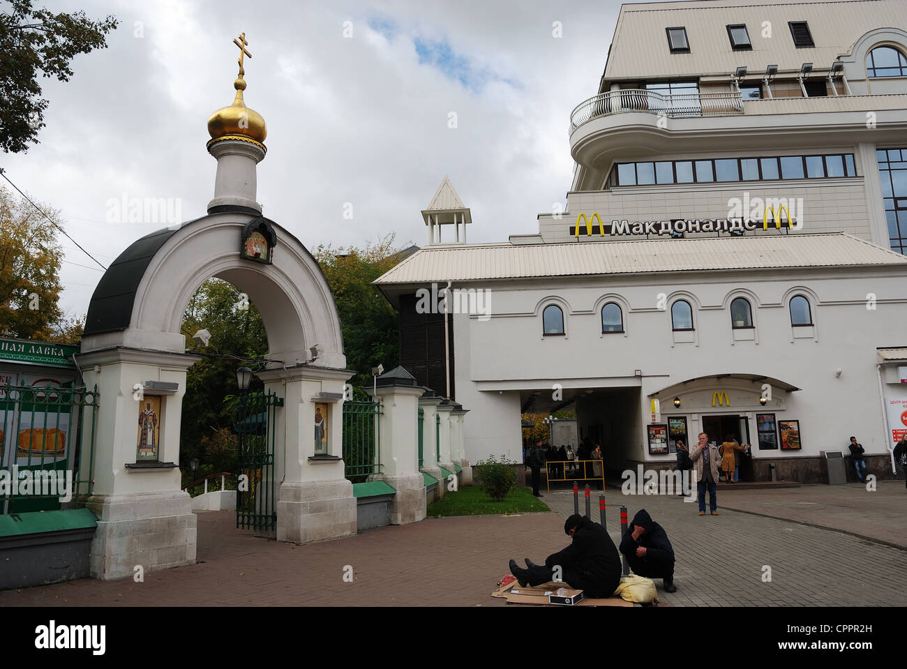 two homeless people near the gate of the Orthodox Trinity Church ...