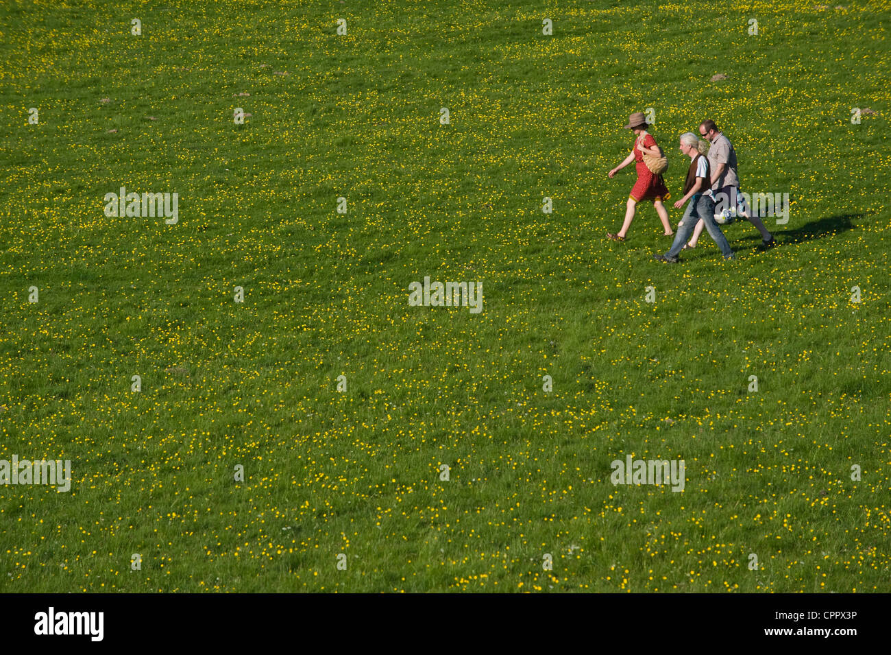 People walking through riverside meadow at The Warren Hay on Wye Powys ...