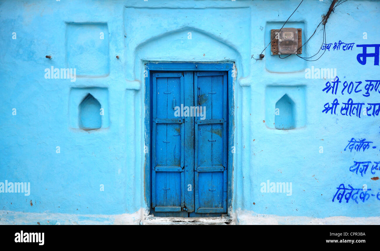 Blue wooden door in a blue wall with blue writing in Orchha, India ...