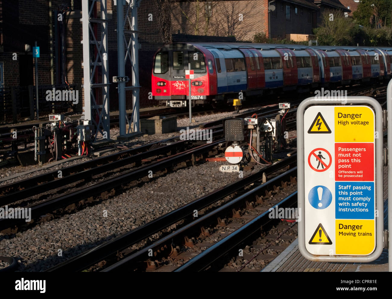 Tube train on the tracks with warning sign Stock Photo - Alamy