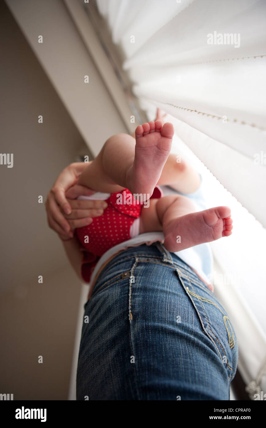 Low angle view of a mom holding her four month old baby girl, bottom of ...