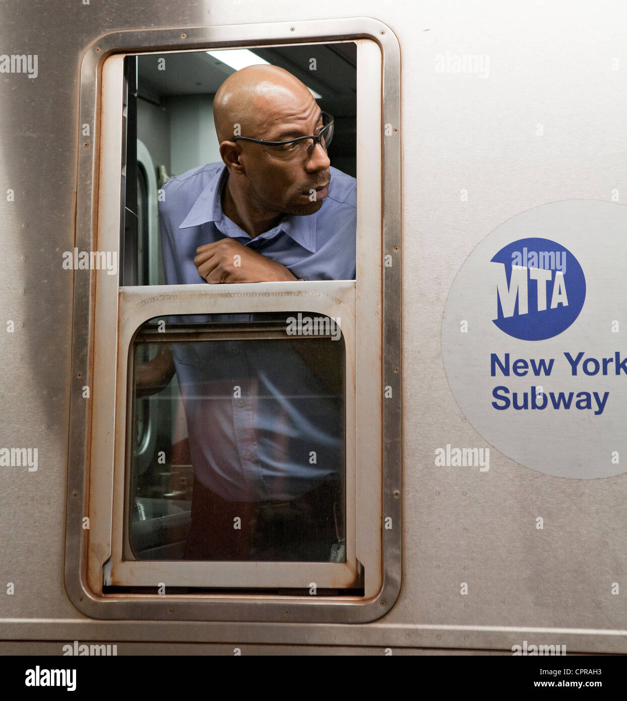A subway driver in New York City looks back to check on riders Stock ...