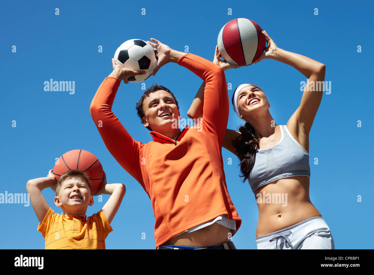 Portrait of happy family throwing balls while playing outside Stock ...