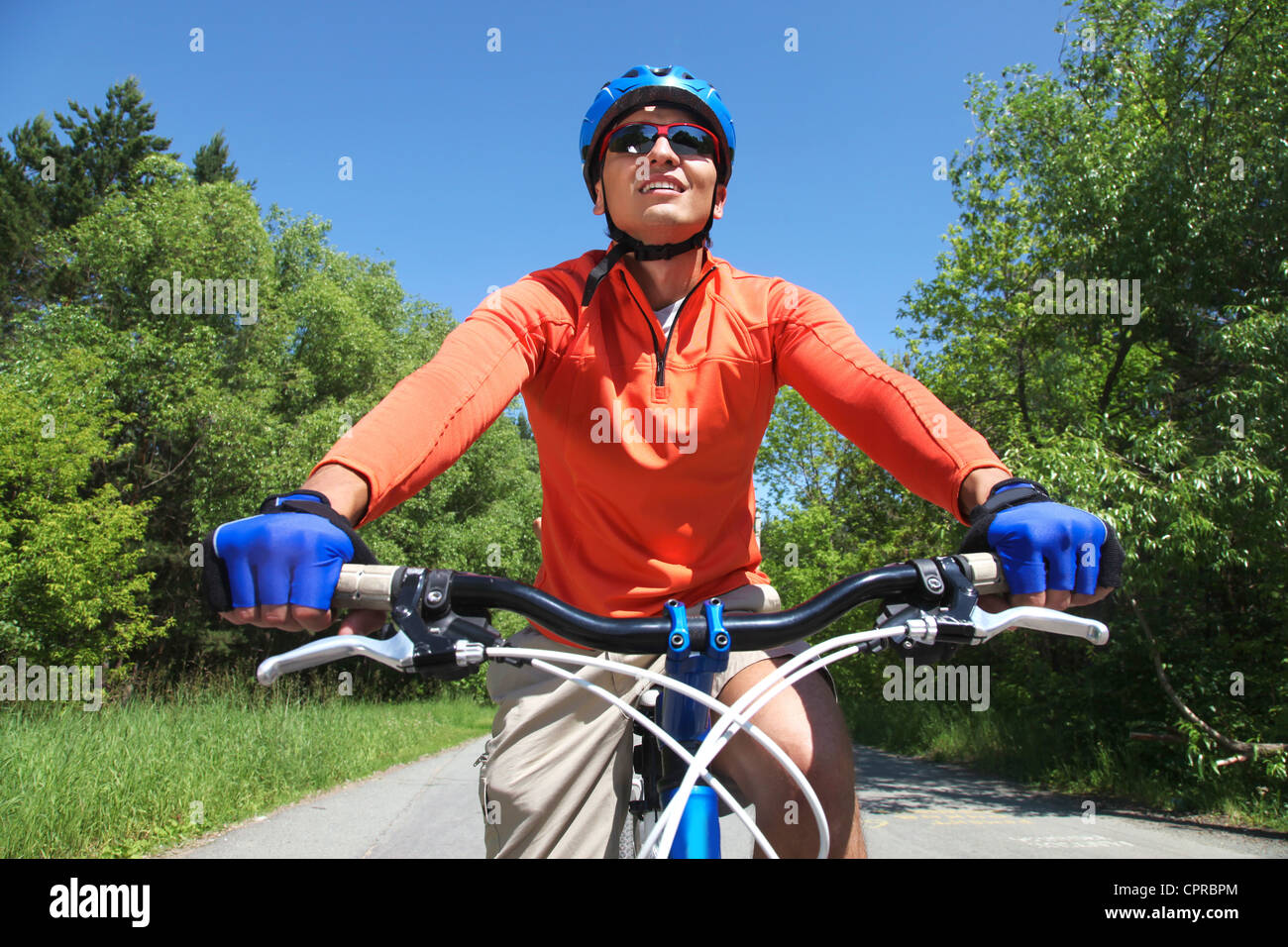 Portrait of a handsome man riding a bike Stock Photo - Alamy