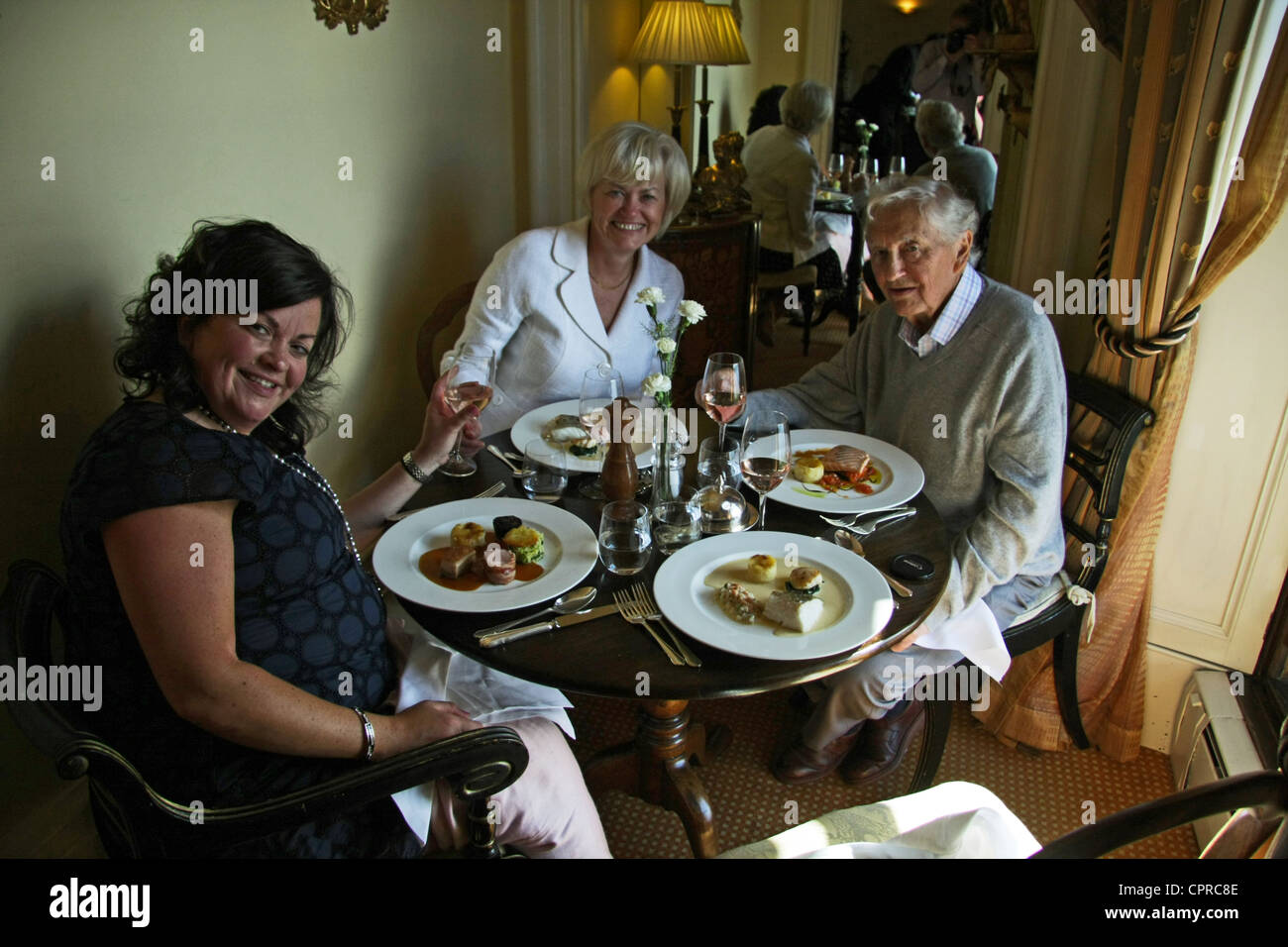 three diners in a restaurant, table set for four Stock Photo - Alamy